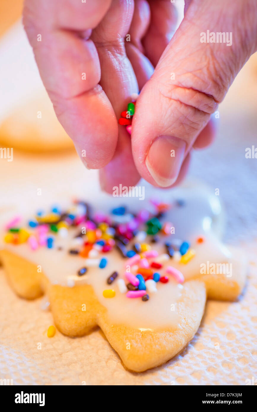 Human hand sprinkling rainbow icing over cookies Stock Photo - Alamy