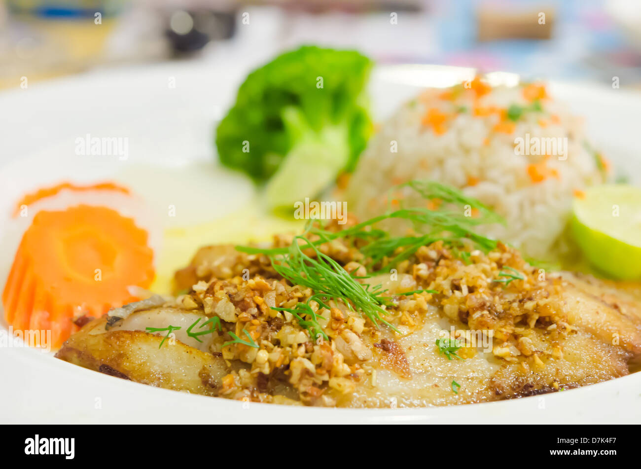 fish steak served with fried rice and vegetable on white dish Stock ...