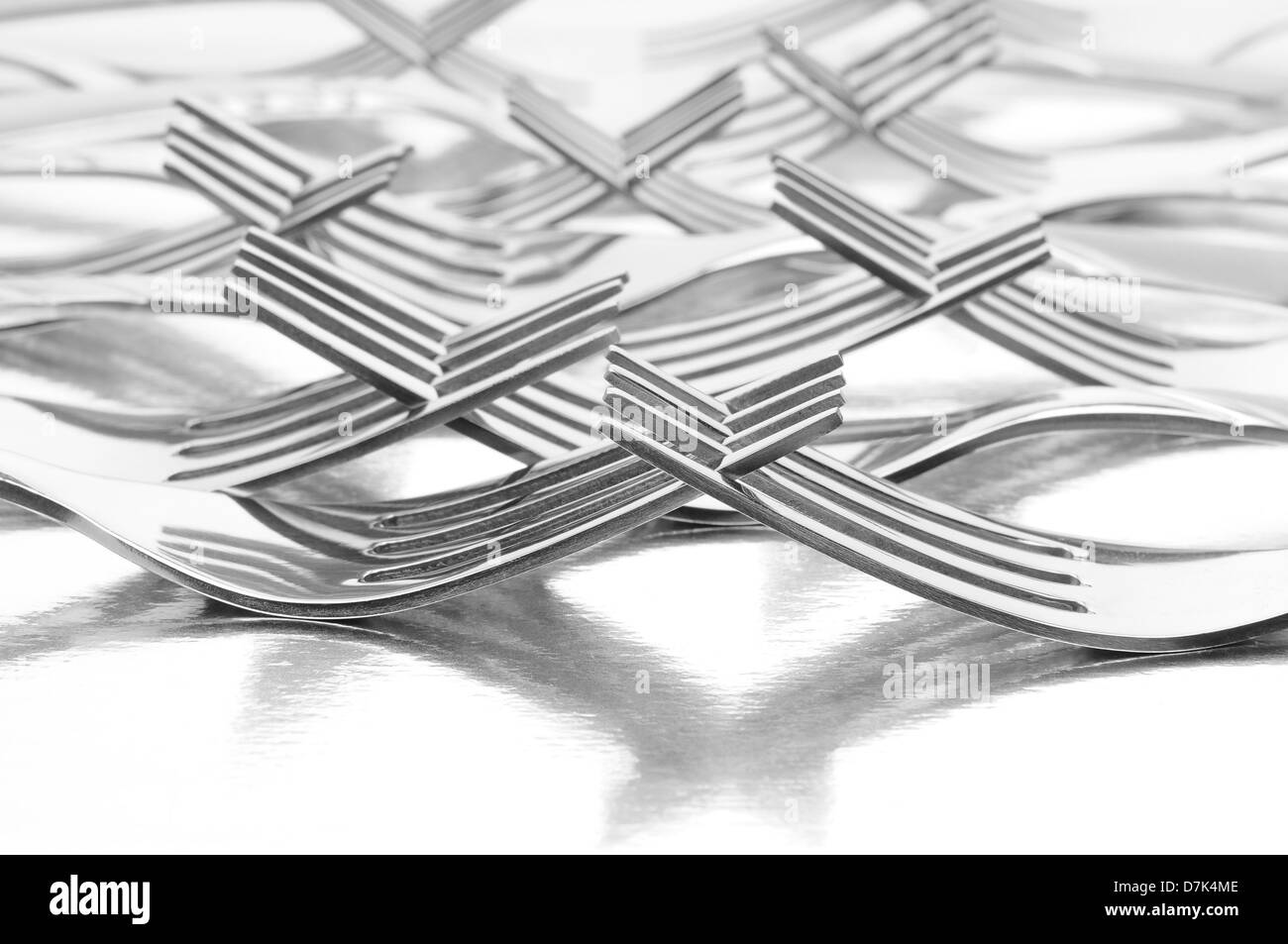 Group of forks with their tines intertwined with reflection on a shiny ...