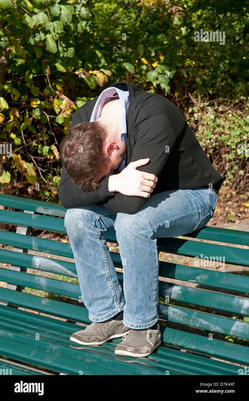 Germany, Berlin, Depressed man sitting on park bench Stock Photo - Alamy