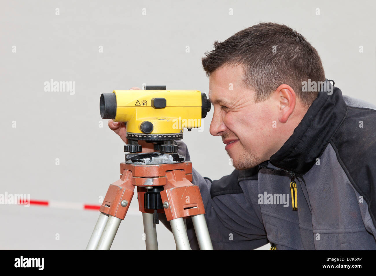 Mature man looking through theodolite Stock Photo - Alamy