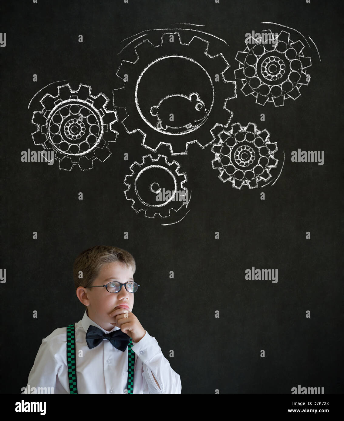 Thinking boy dressed up as business man with chalk turning gear cogs ...
