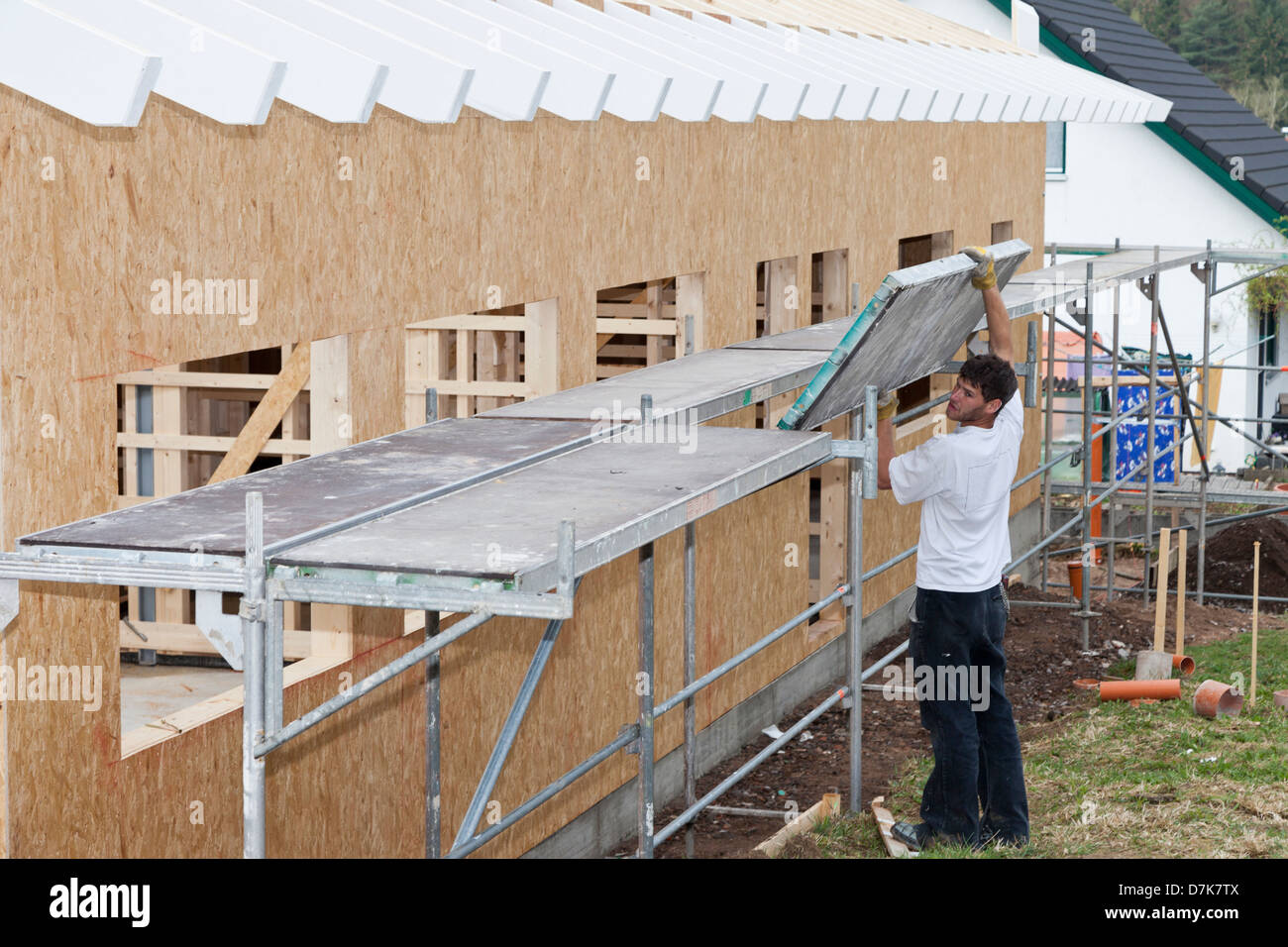 Europe, Germany, Rhineland Palatinate, Young man assembling scaffold ...