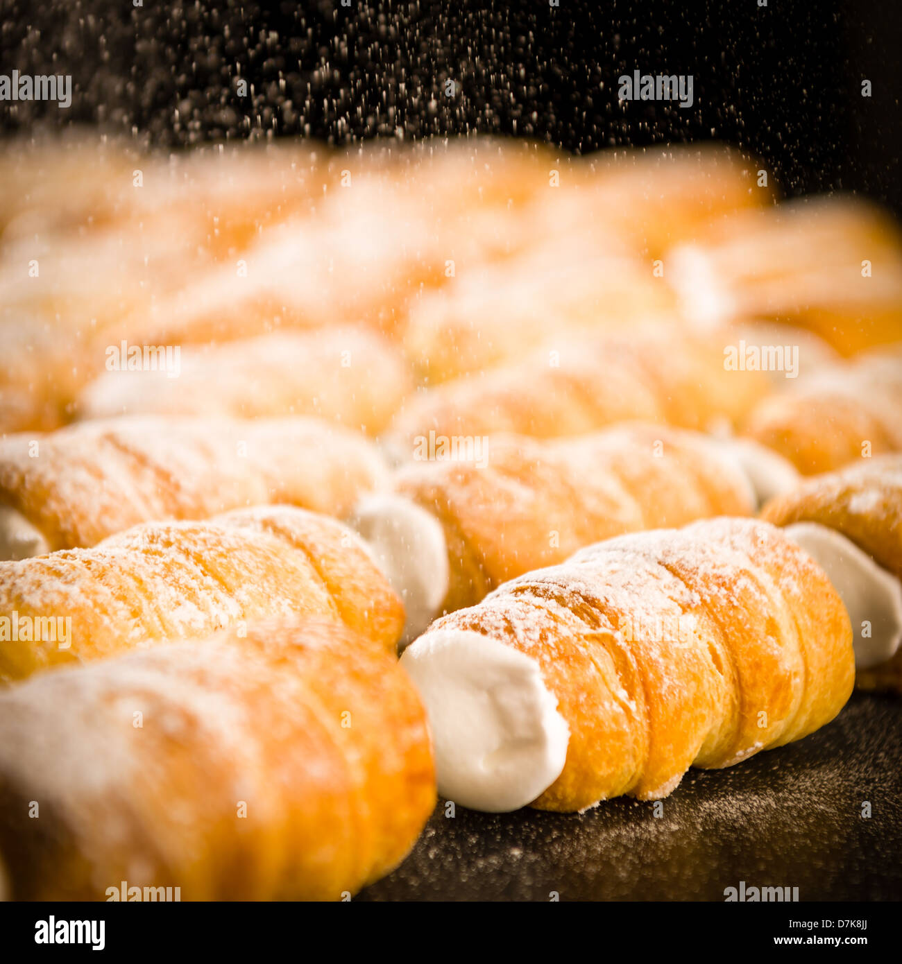 Powder sugar falling to cream horns filled with whipped cream Stock ...