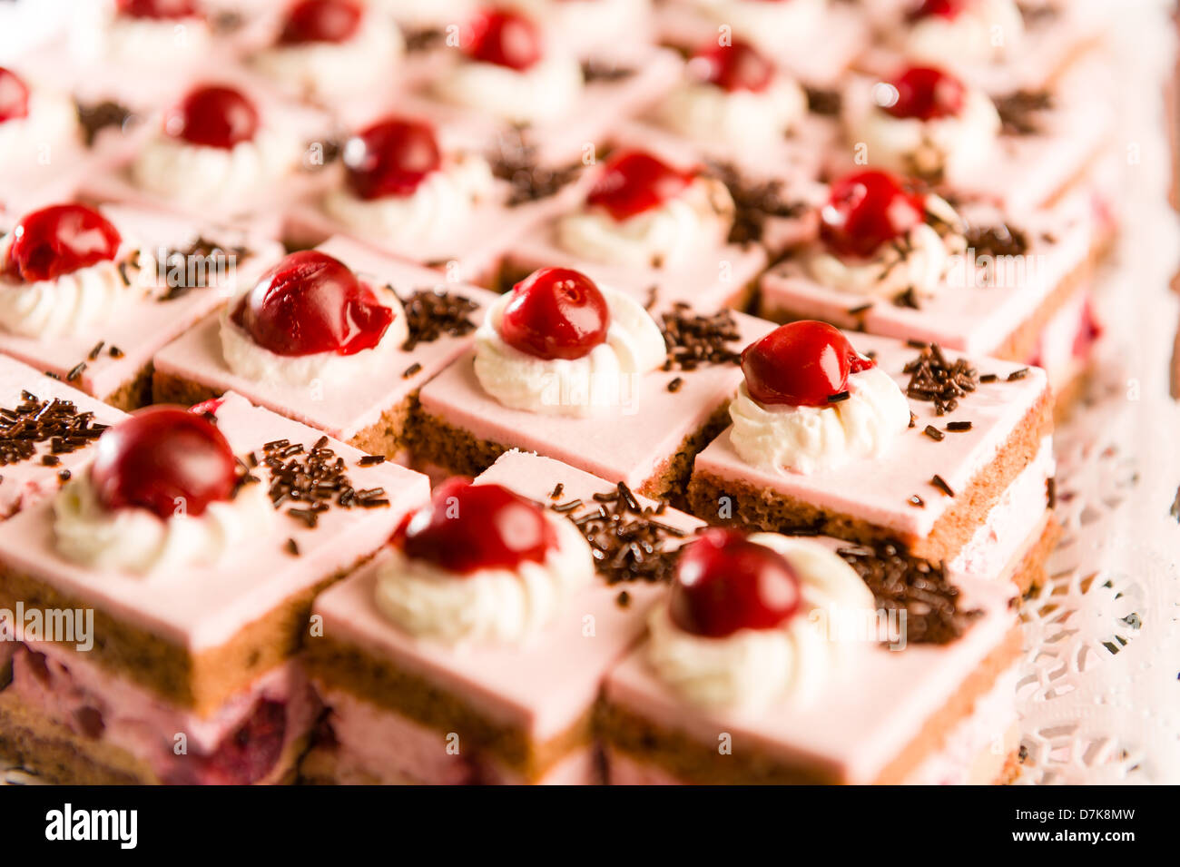 Cream filled cakes with cherry and chocolate topping Stock Photo - Alamy