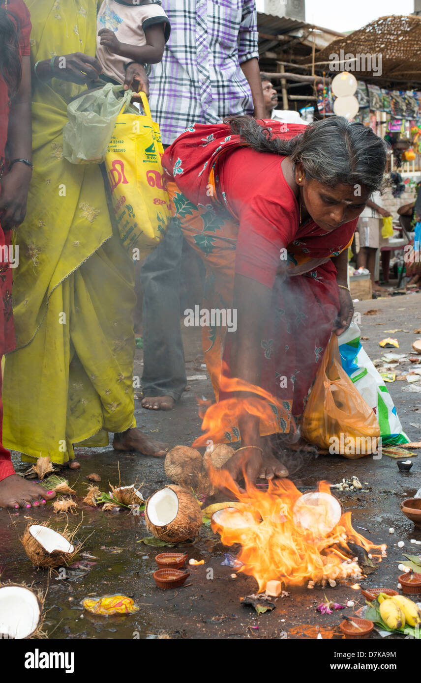 A Hindu devotee adds camphor to a fire as an offering at the ...