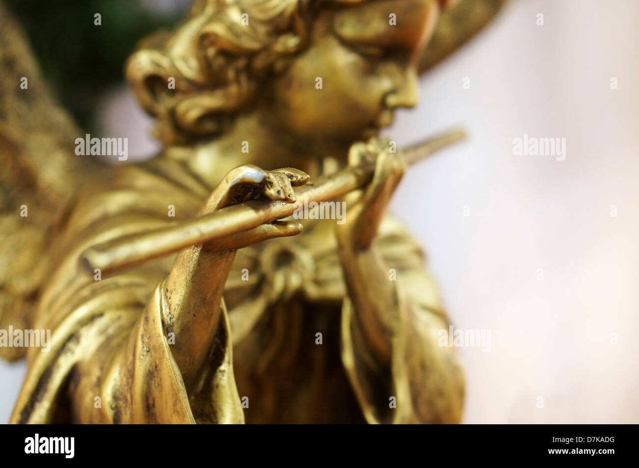 Golden angel figurine playing flute hi-res stock photography and images ...