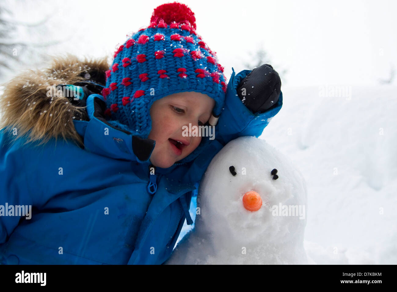 4-5 year old boy whispers into a snowman's ear Stock Photo - Alamy