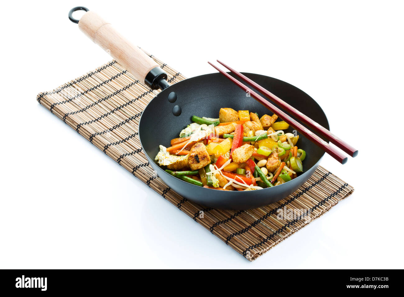 Chinese food in wok with chopsticks placed on straw mat Stock Photo - Alamy