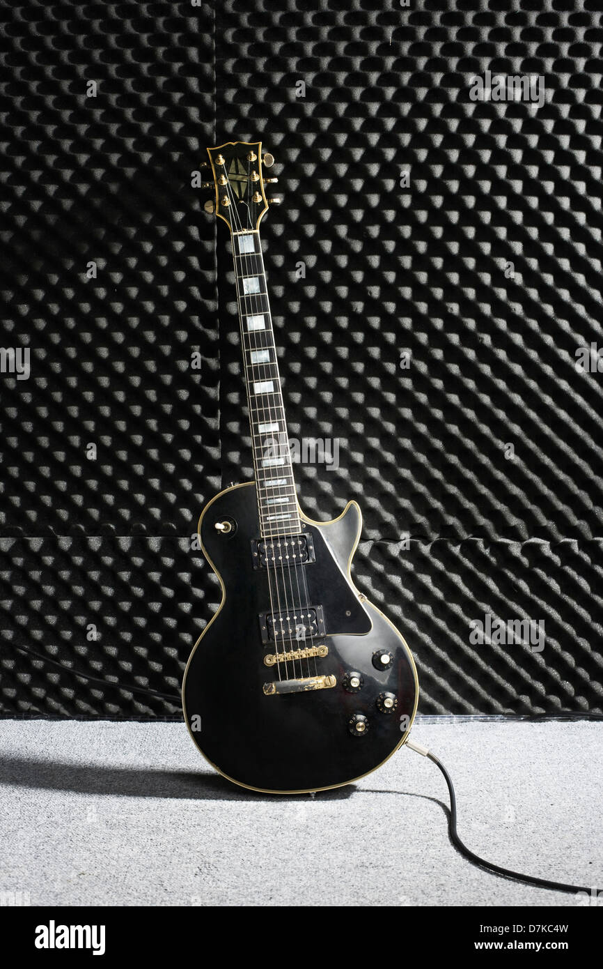 Germany, Electric bass guitar against wall, close up Stock Photo - Alamy