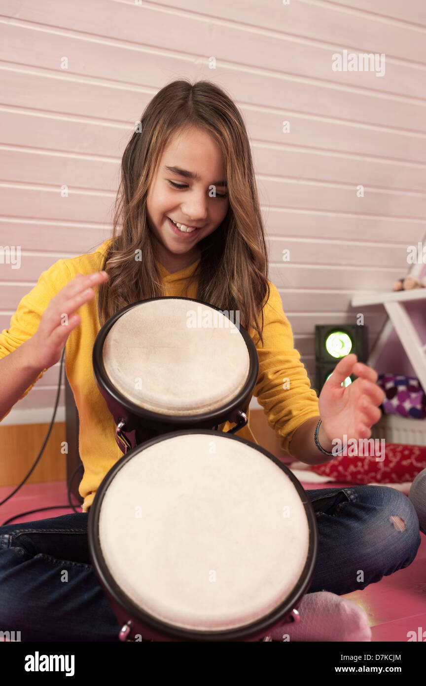 Girl playing drums, smiling Stock Photo - Alamy