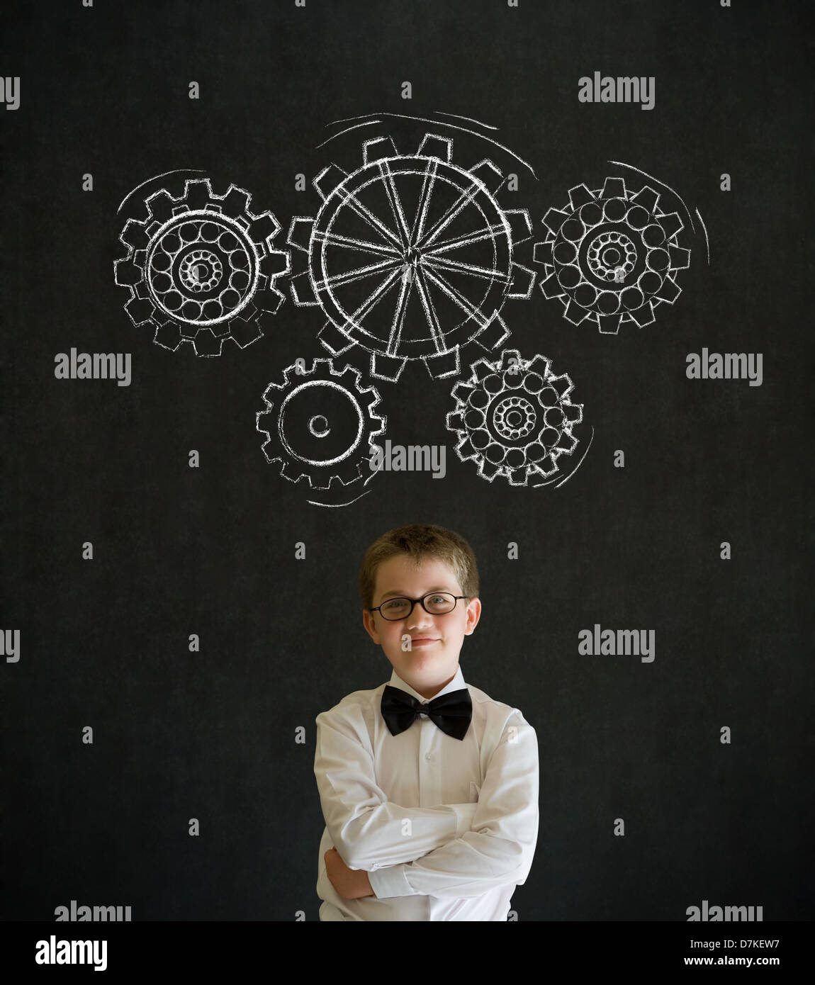 Thinking boy dressed up as business man with chalk turning gear cogs or ...