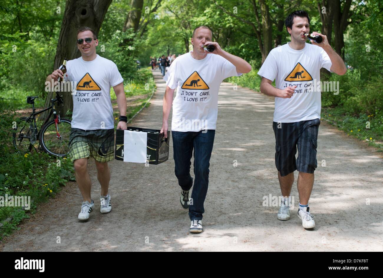 Three young men run around Maschsee Lake with a crate of beer in ...