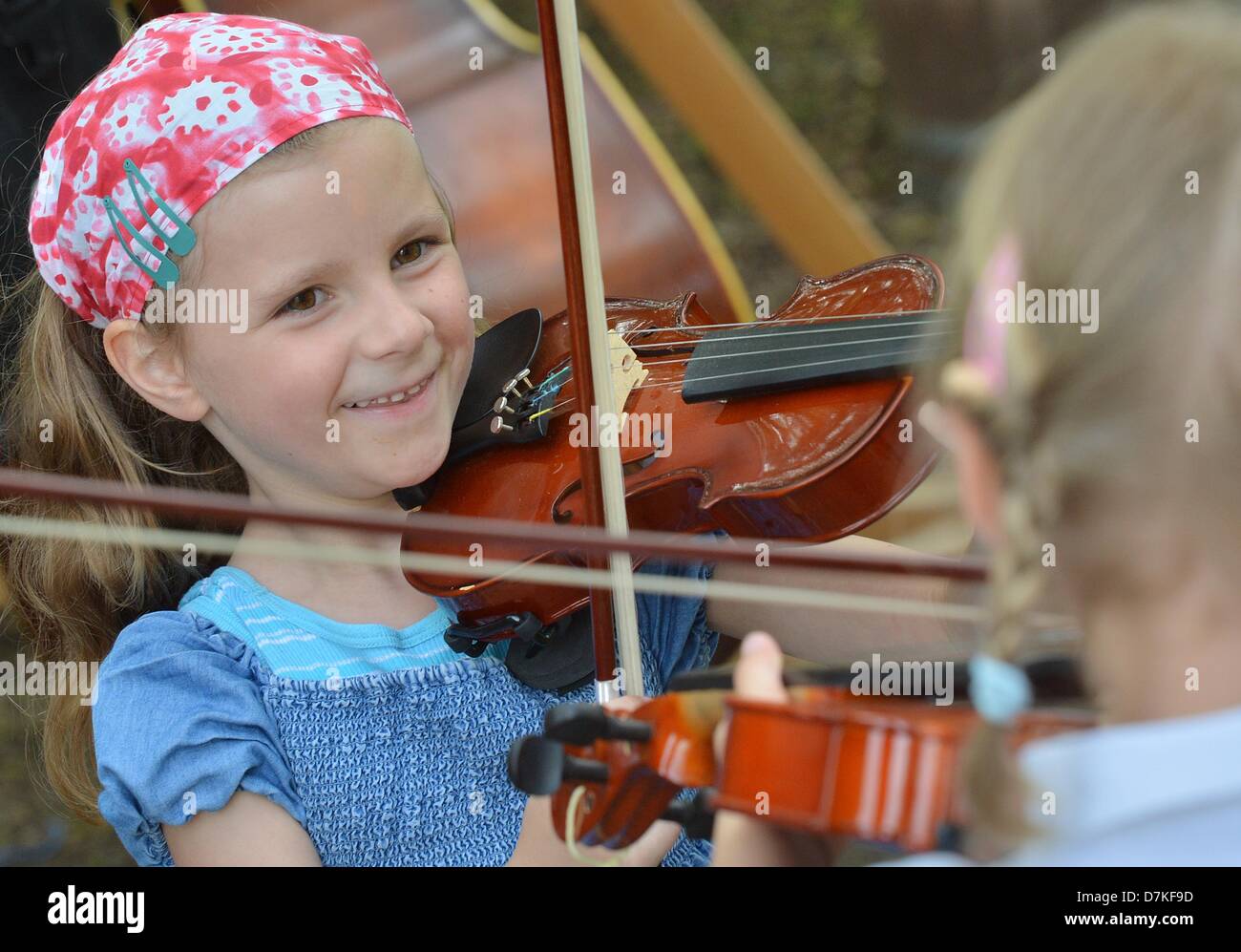 Six year-old Ronja tries a violin from the Mozart Society at the 5th ...