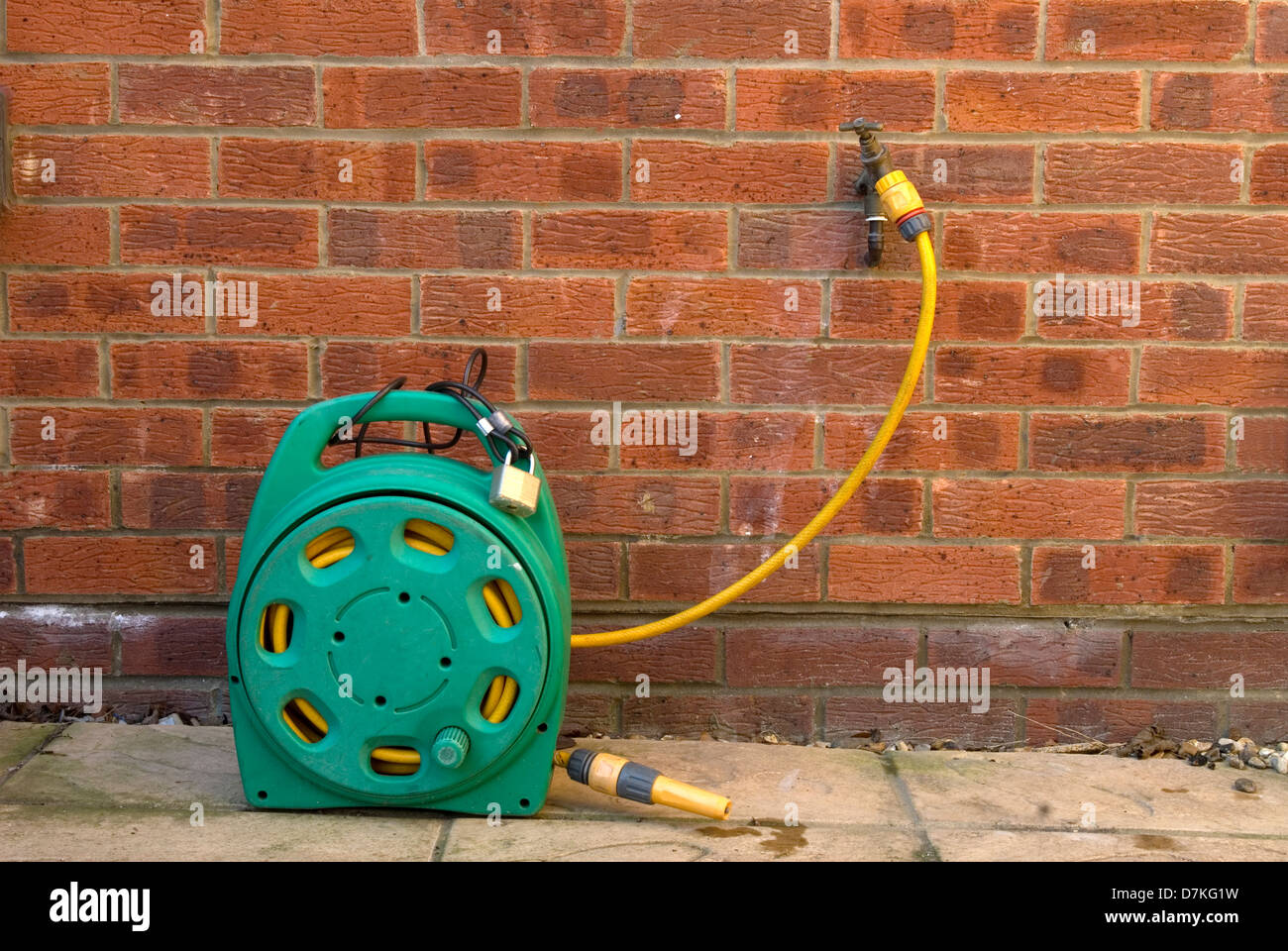 saving water lock up hose pipe against wall Stock Photo - Alamy