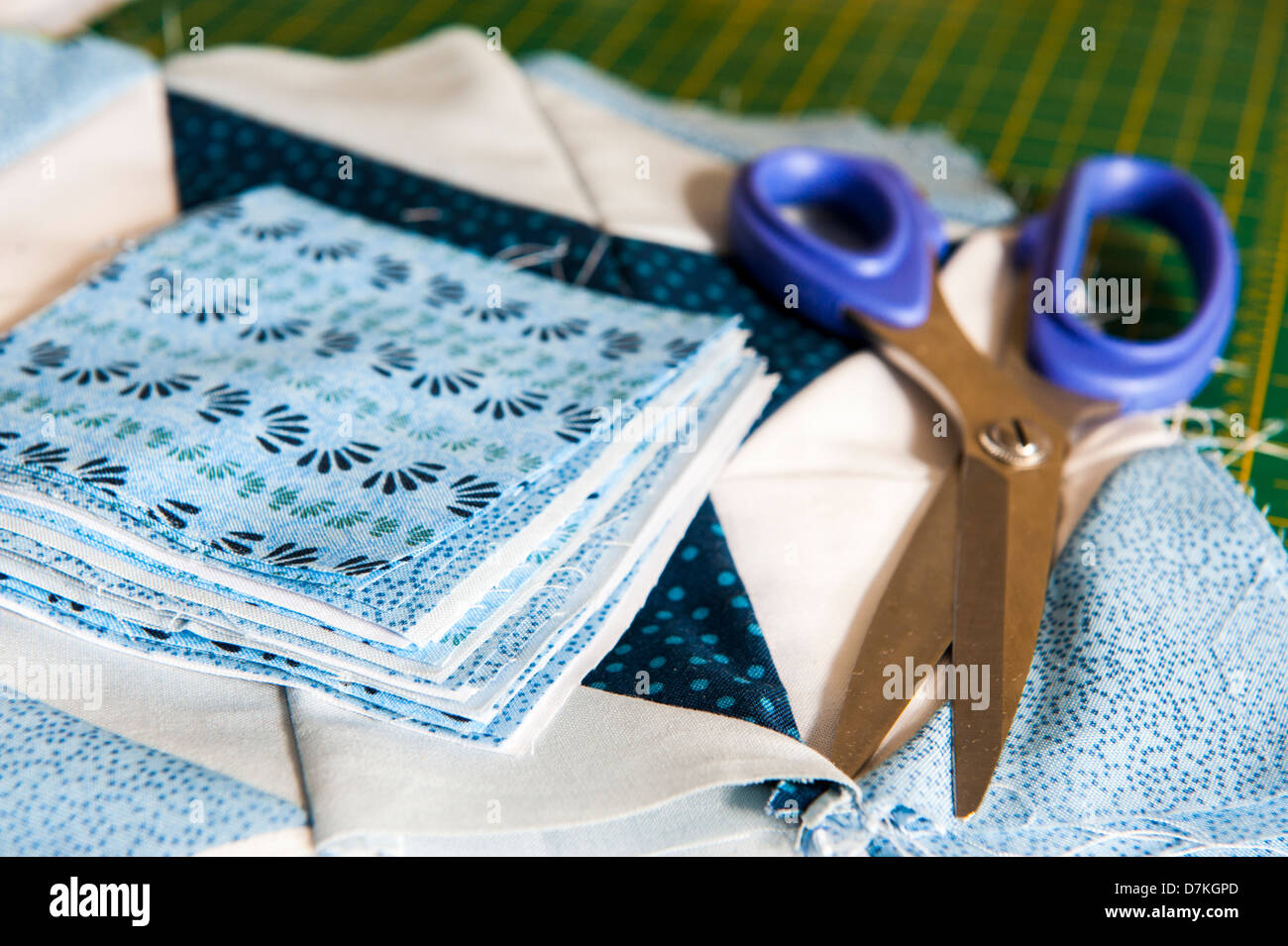 Quilting or patchwork materials and tools on a green measuring board ...