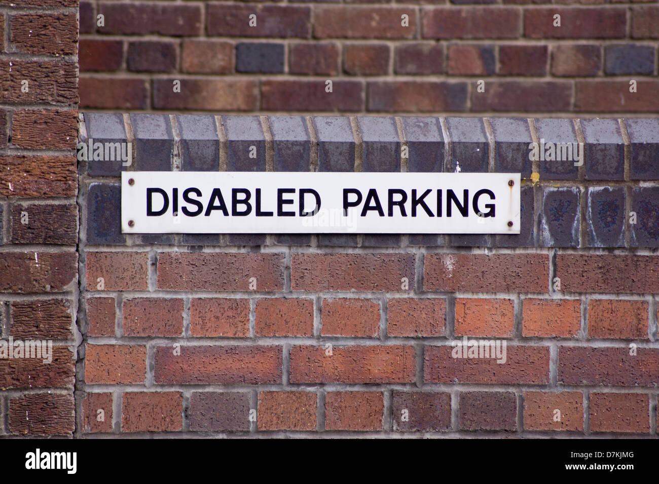 Disabled parking sign on a brick wall Stock Photo - Alamy