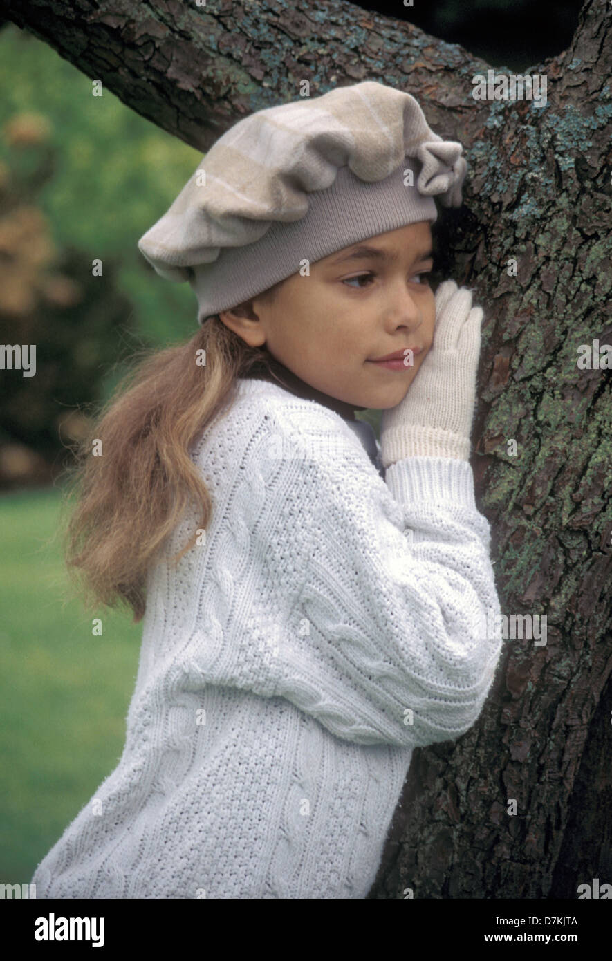 melancholic little girl leaning on tree Stock Photo - Alamy