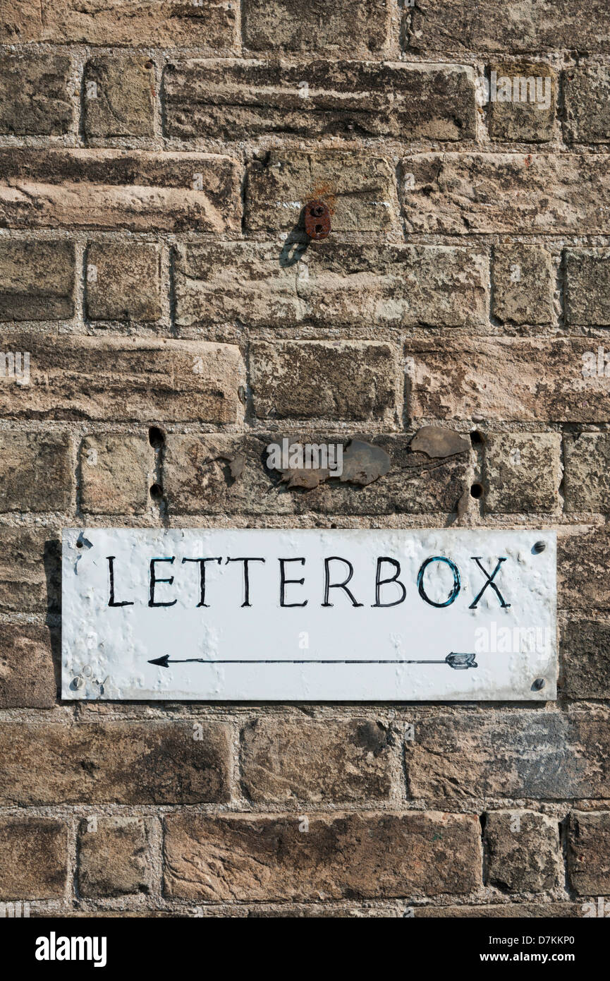 A sign pointing towards a letterbox on a wall in Southwold Suffolk UK ...