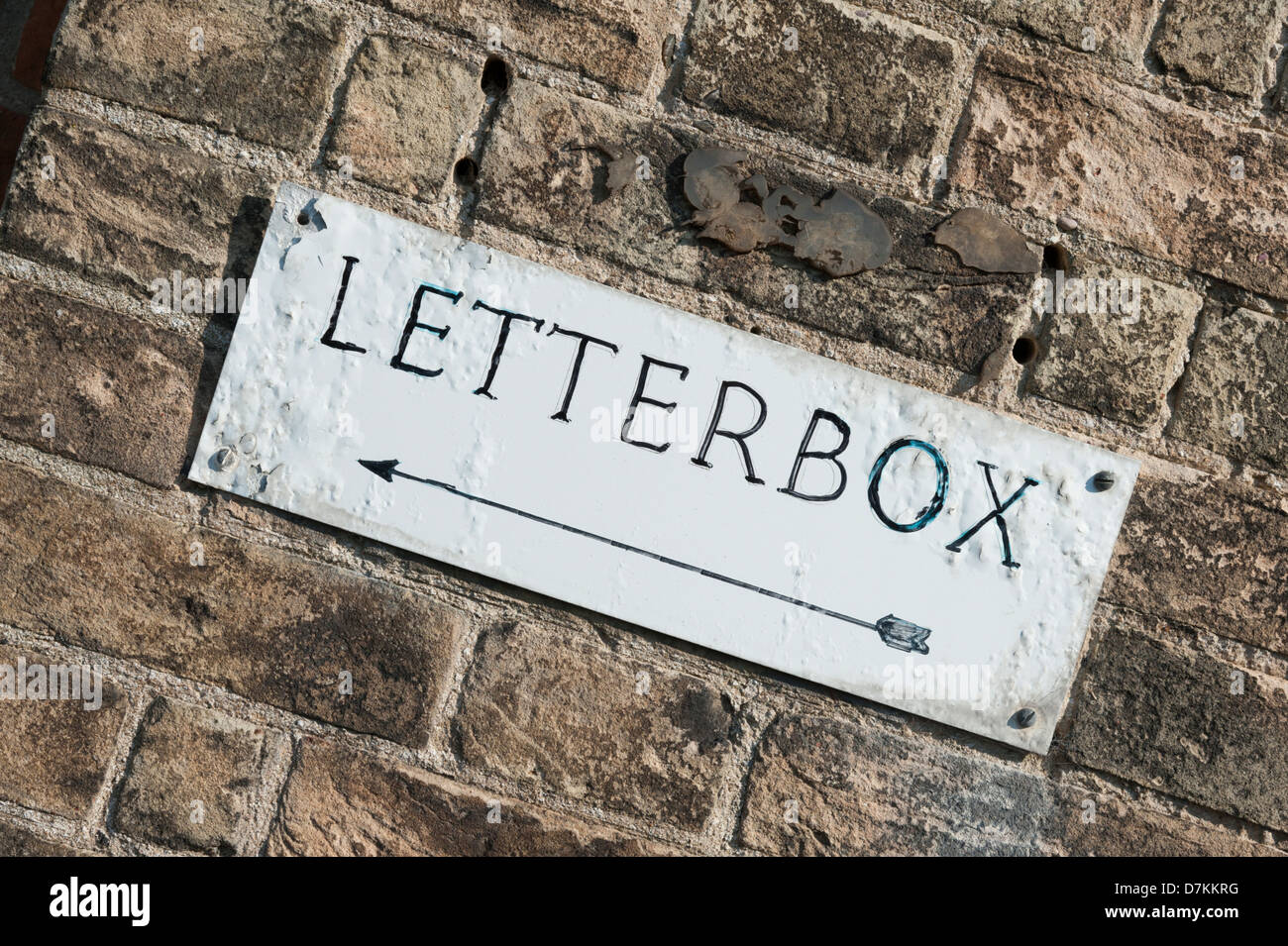 A sign pointing towards a letterbox on a wall in Southwold Suffolk UK ...