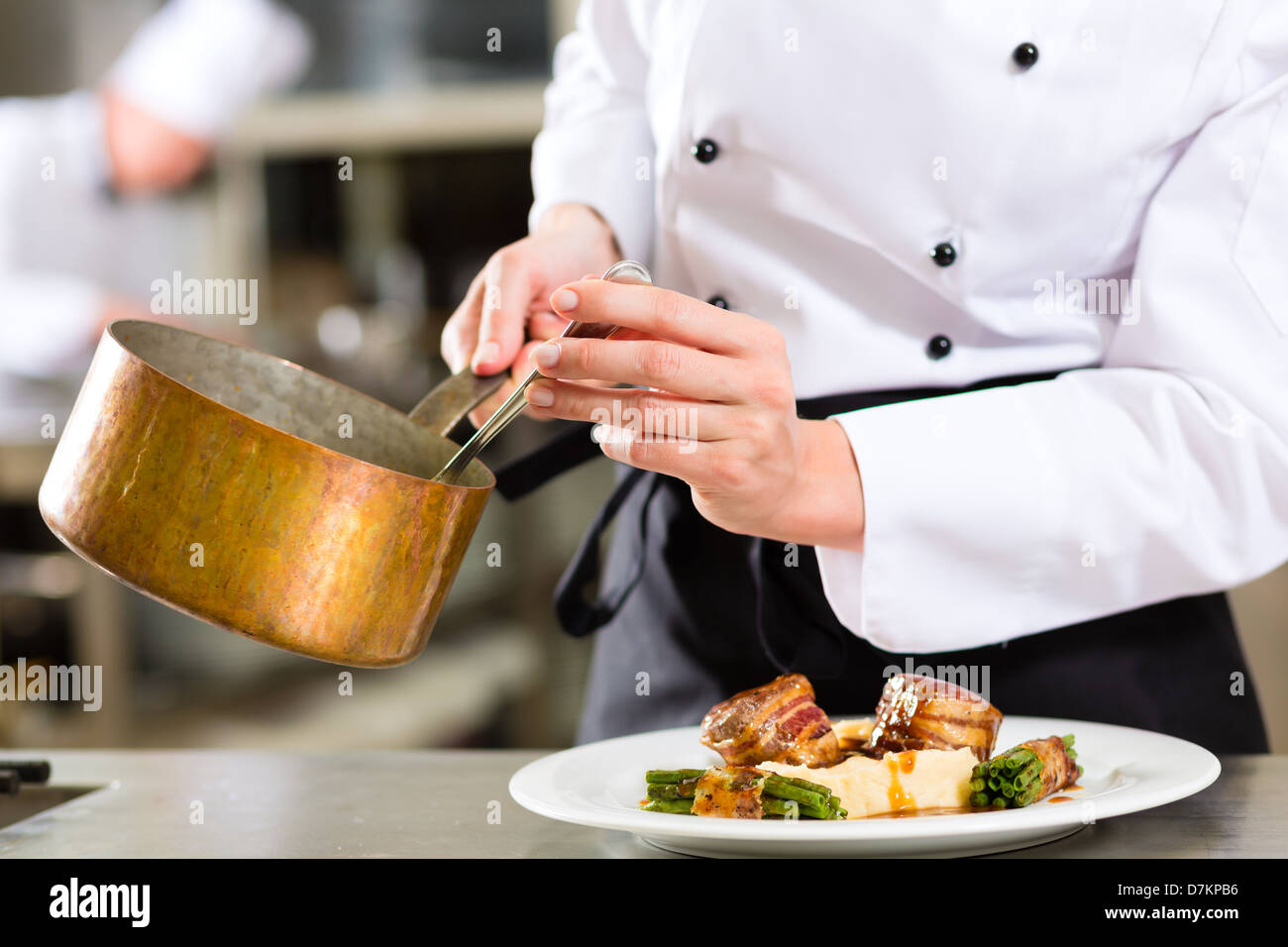 Female Chef in hotel or restaurant kitchen cooking, only hands to be ...