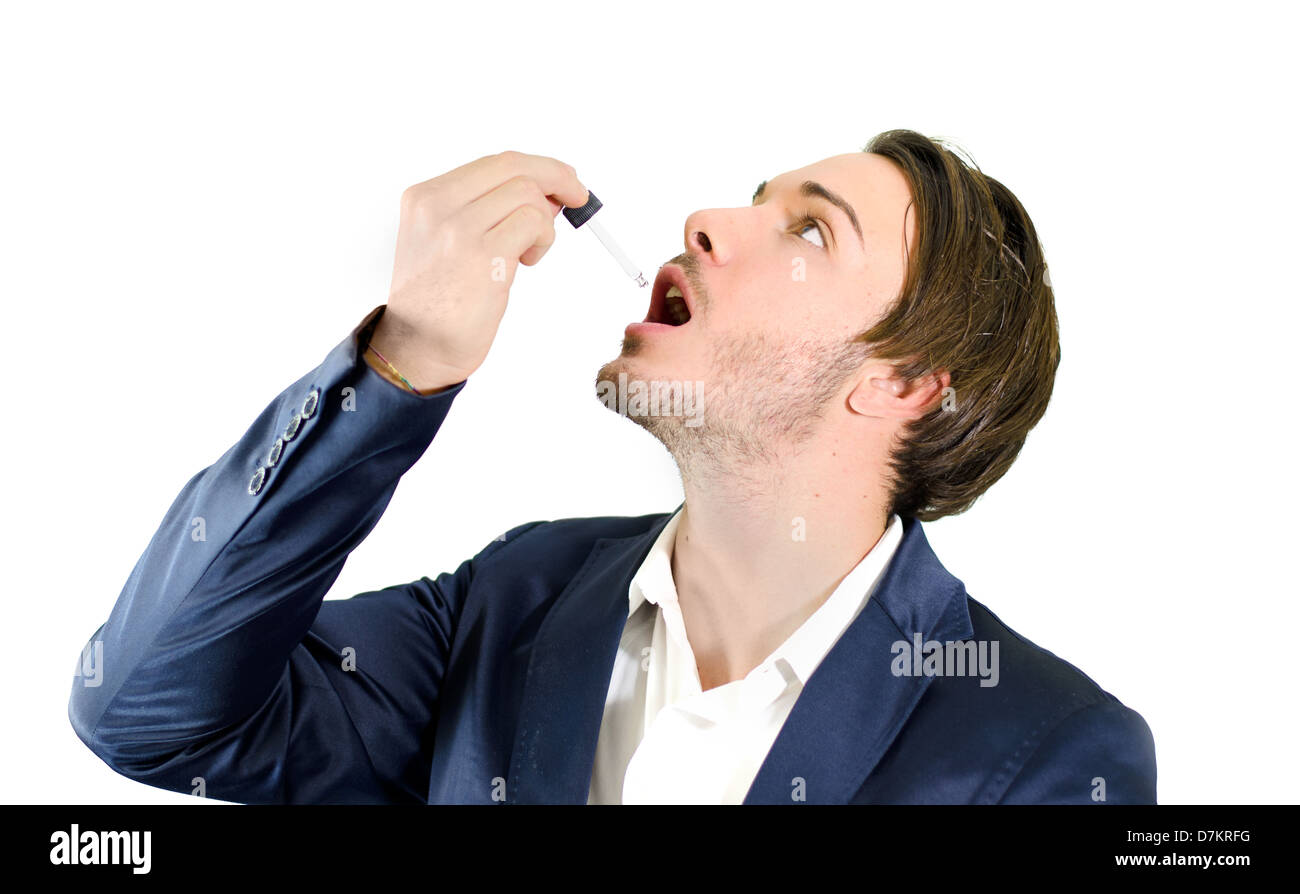 Young man using dropper pipette on his mouth for medicine, drug ...