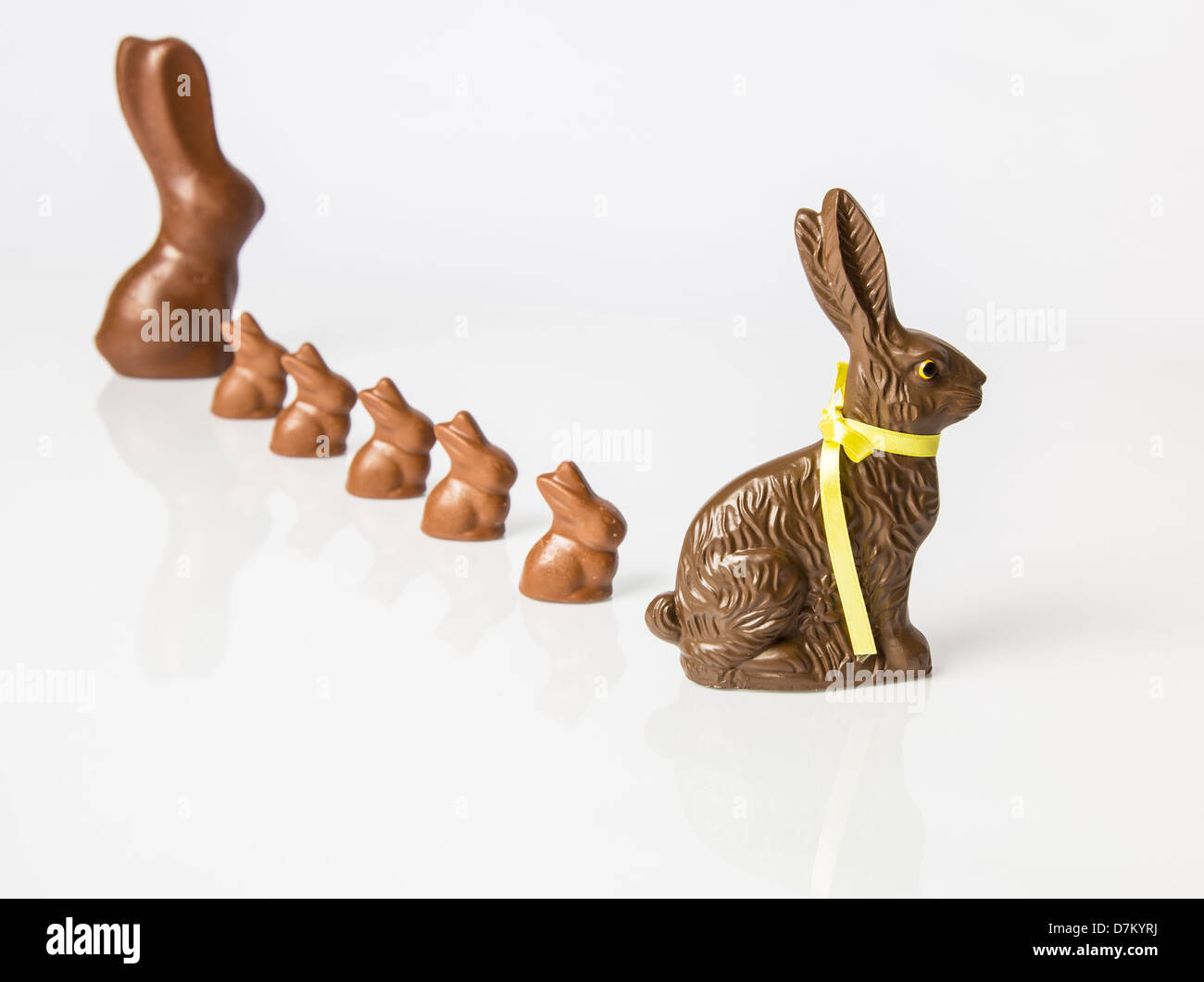 Large Chocolate Easter bunny with smaller chocolate bunnies lined up in ...