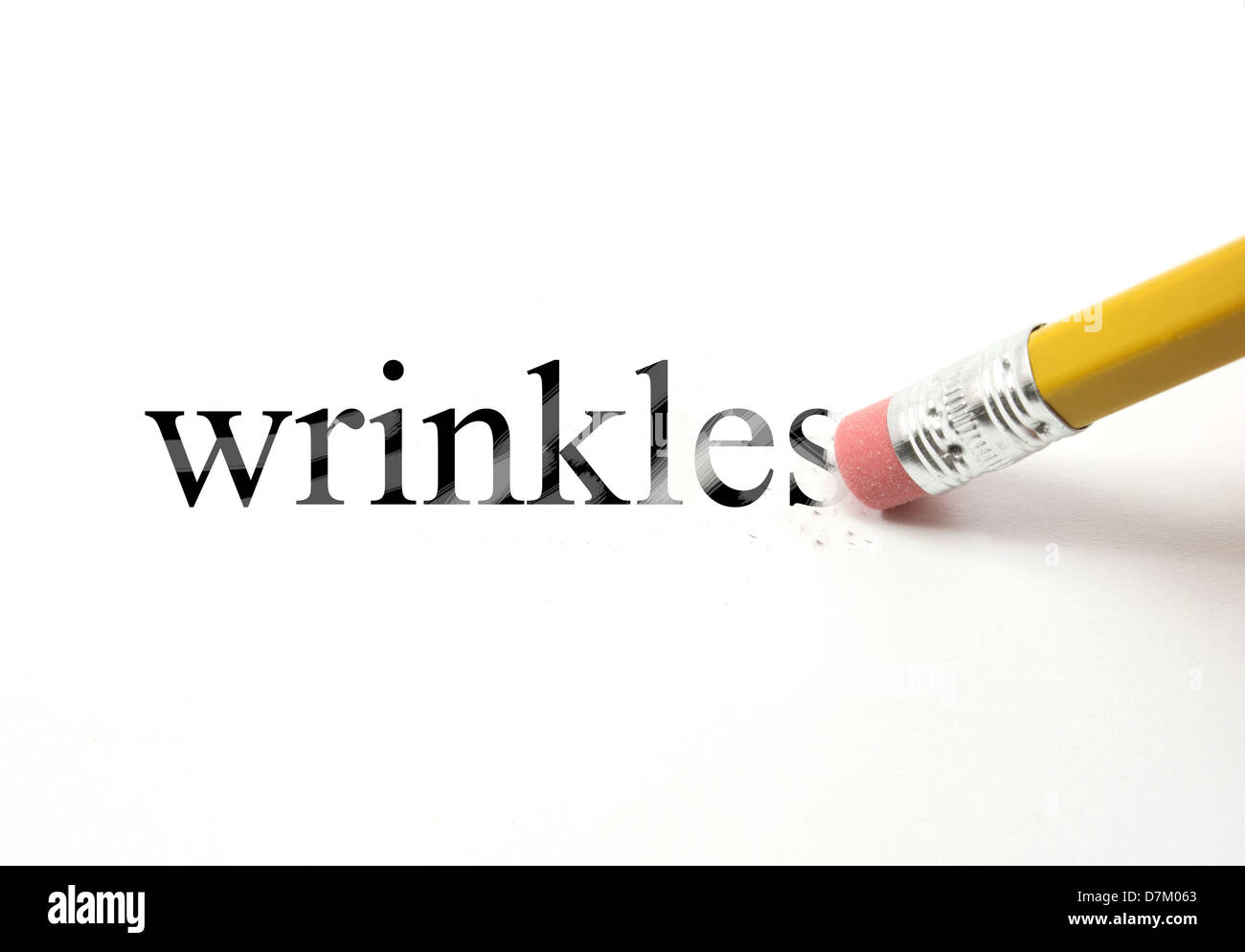 The word wrinkles written on white with the end of a pencil erasing the ...