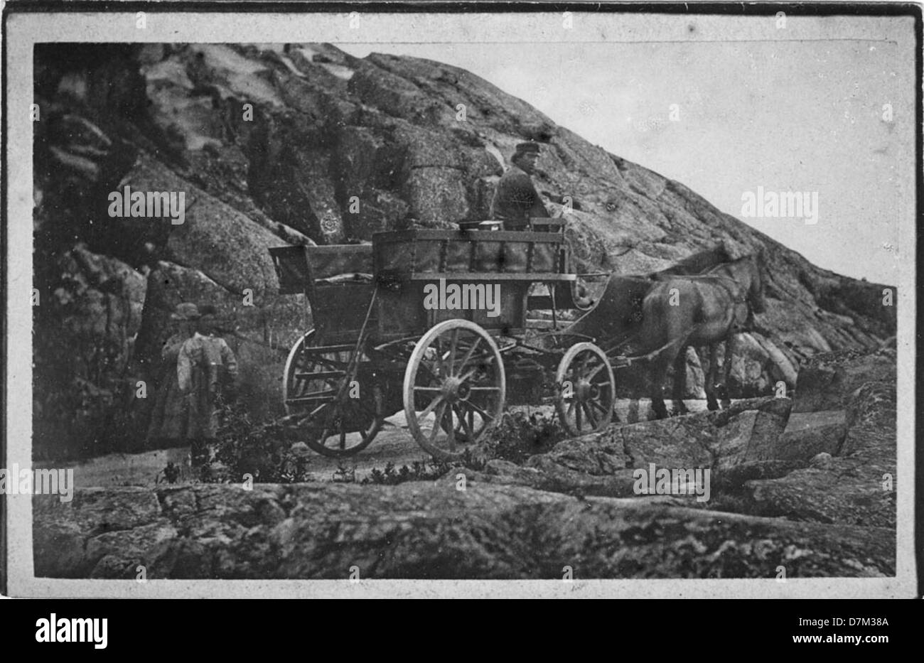 This historic photograph features a horse-drawn carriage with a ...