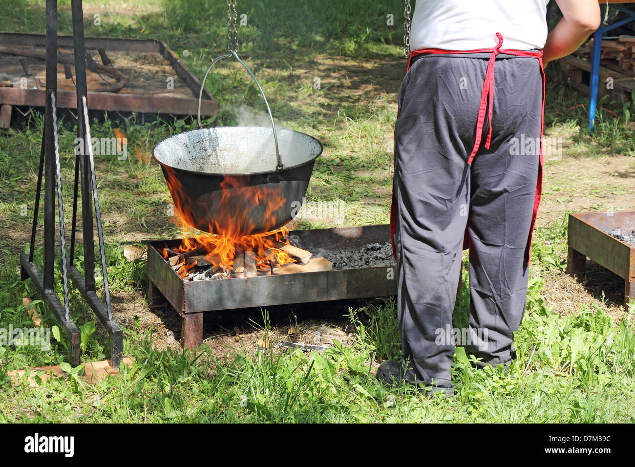 A man cooks food in the kettle over the fire in nature Stock Photo - Alamy