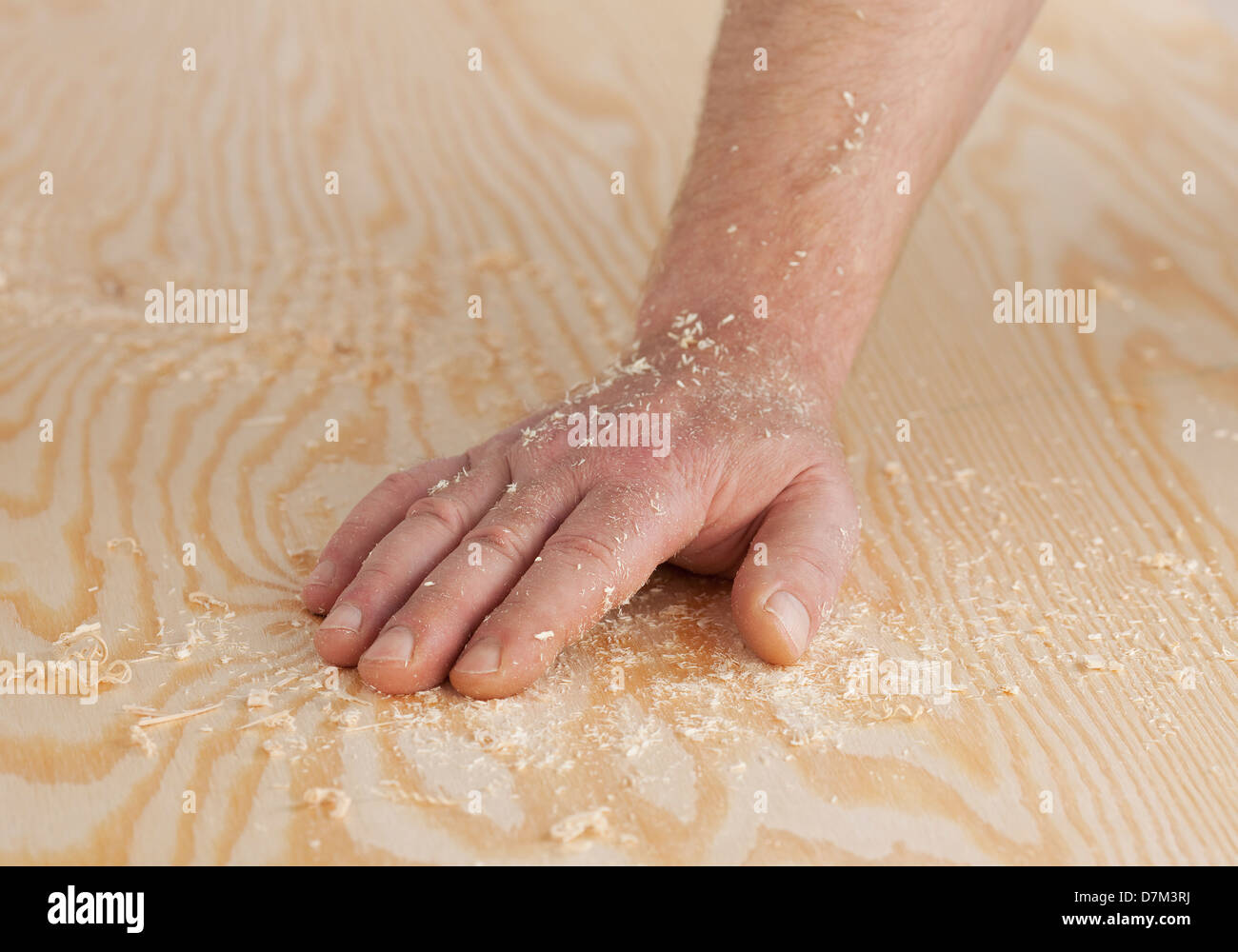 Human hand on wooden board with sawdust Stock Photo - Alamy
