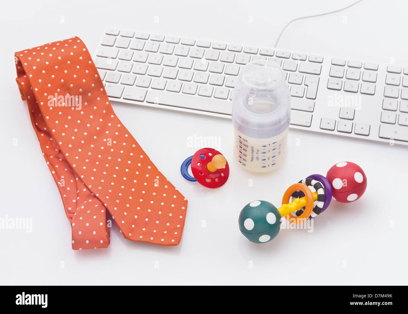 Keyboard, tie, rattle, pacifier and baby bottle on white background ...