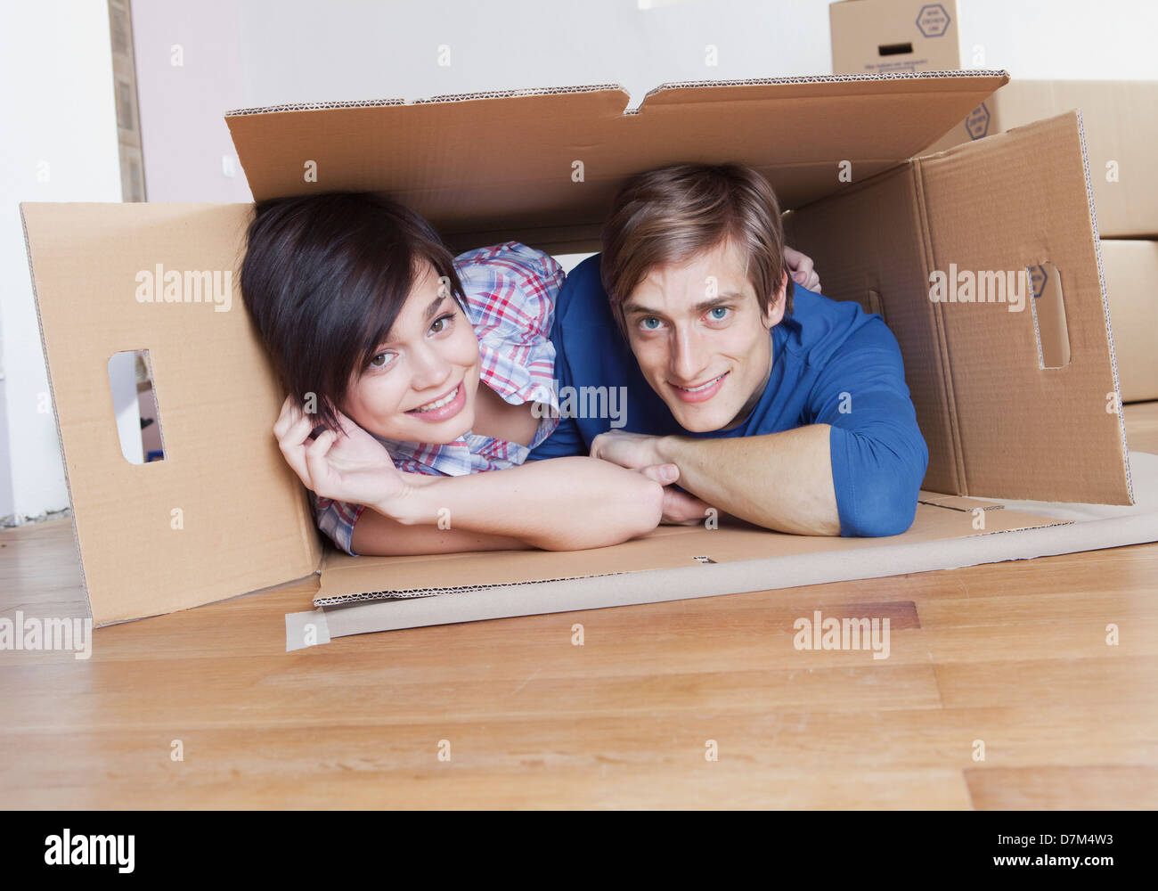 Young couple in cardboard box, smiling, portrait Stock Photo - Alamy
