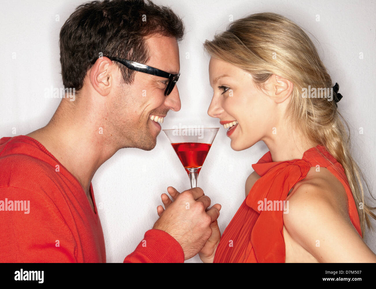 Couple sharing cocktail against white background, close up Stock Photo ...