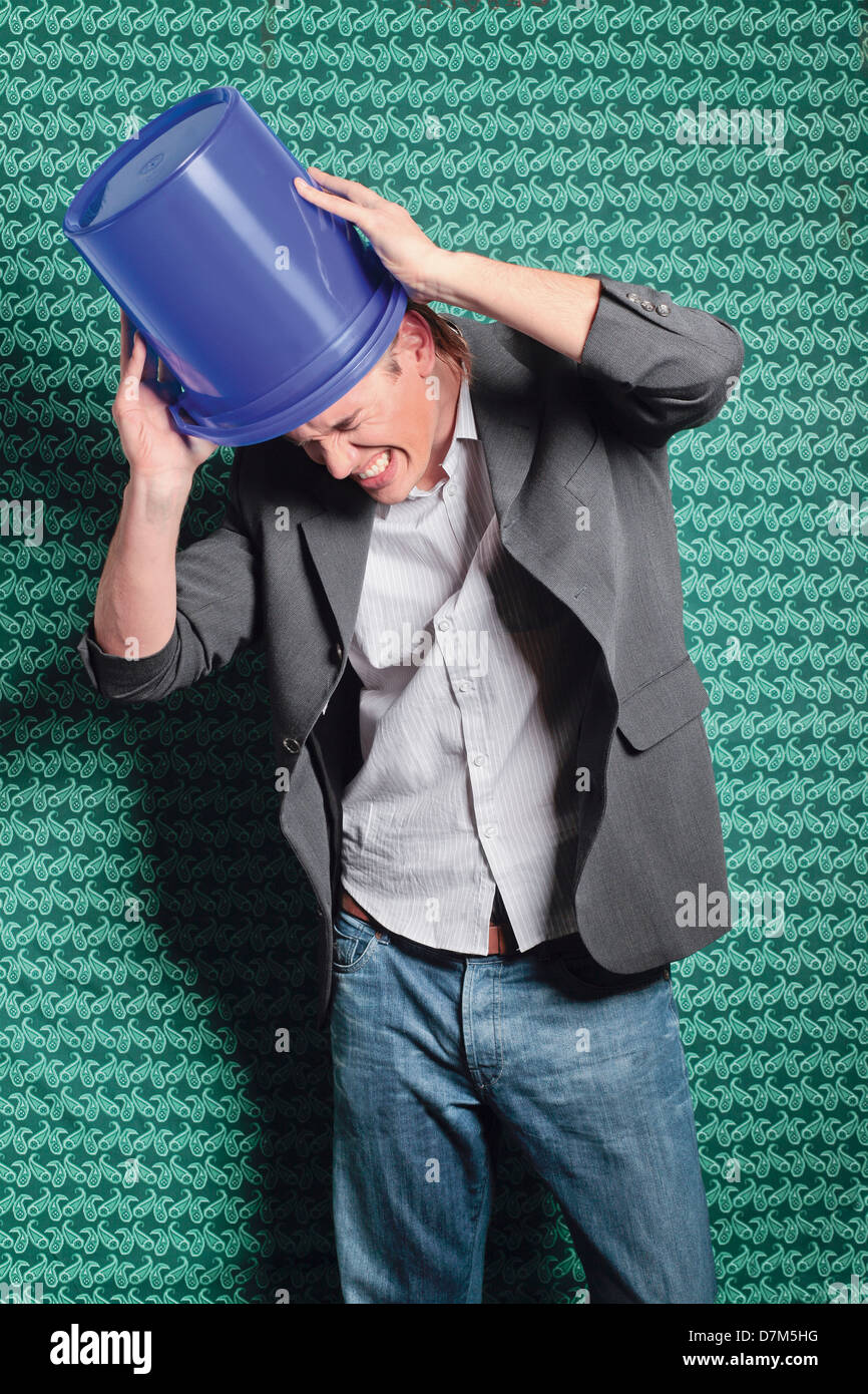 Young man pulling bucket over his head Stock Photo - Alamy