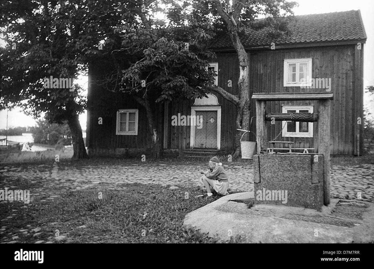 A photograph of a young girl at a well in Pataholm, Småland, Sweden ...