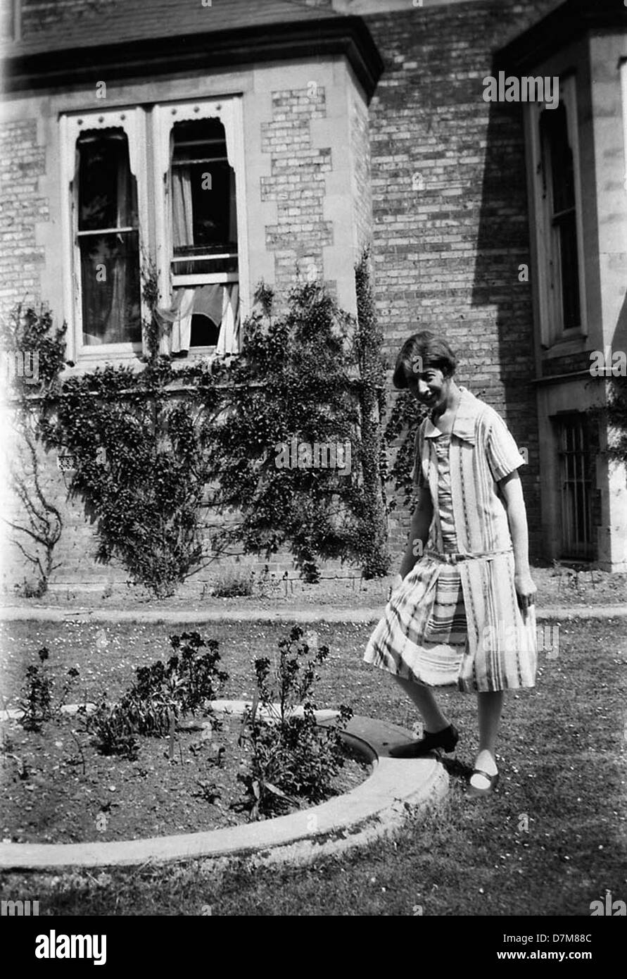 This photograph shows Miss Miles standing in front of Bridge House in ...