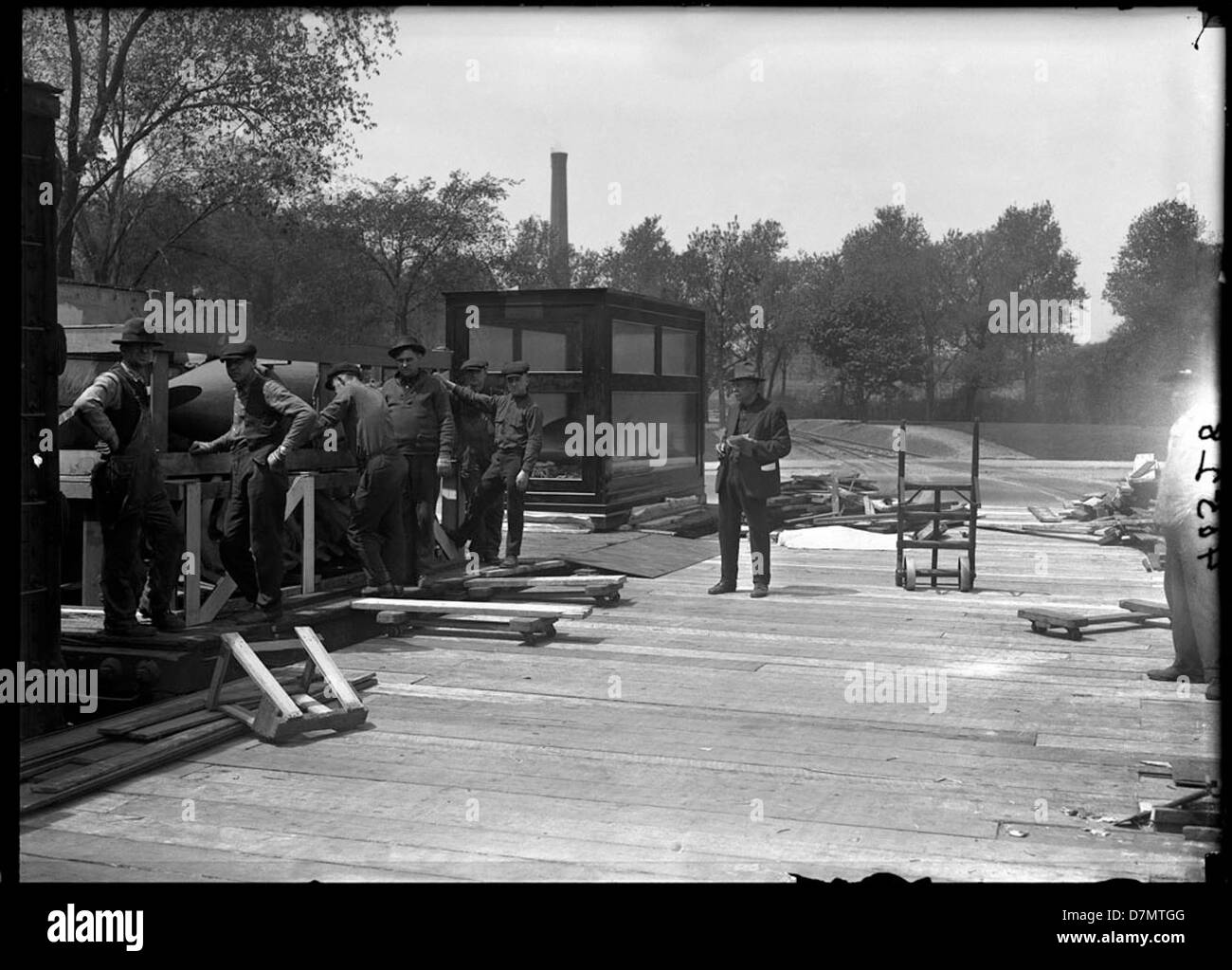 Men are shown moving exhibit cases as part of the preparation for a ...