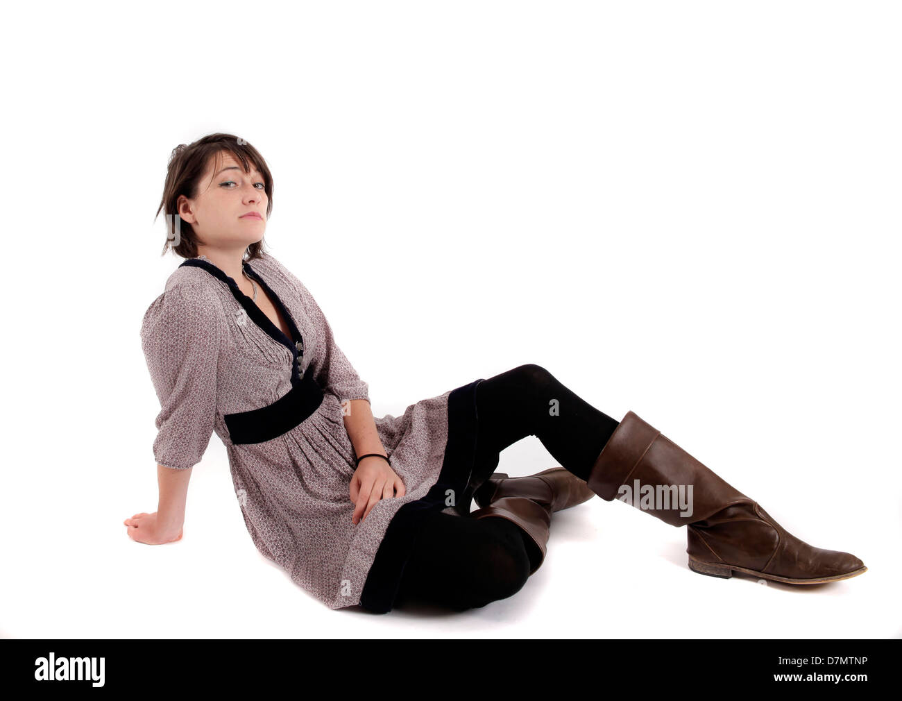 portrait of a young woman lengthened on the ground in grey dress Stock ...