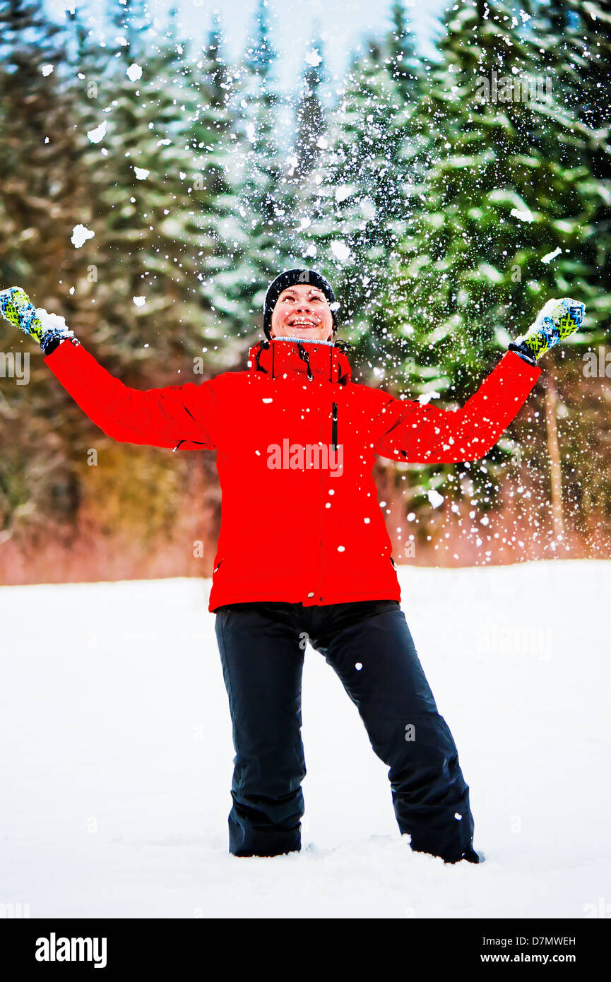 Female throwing a pile of snow up into the air. Female is in focus ...