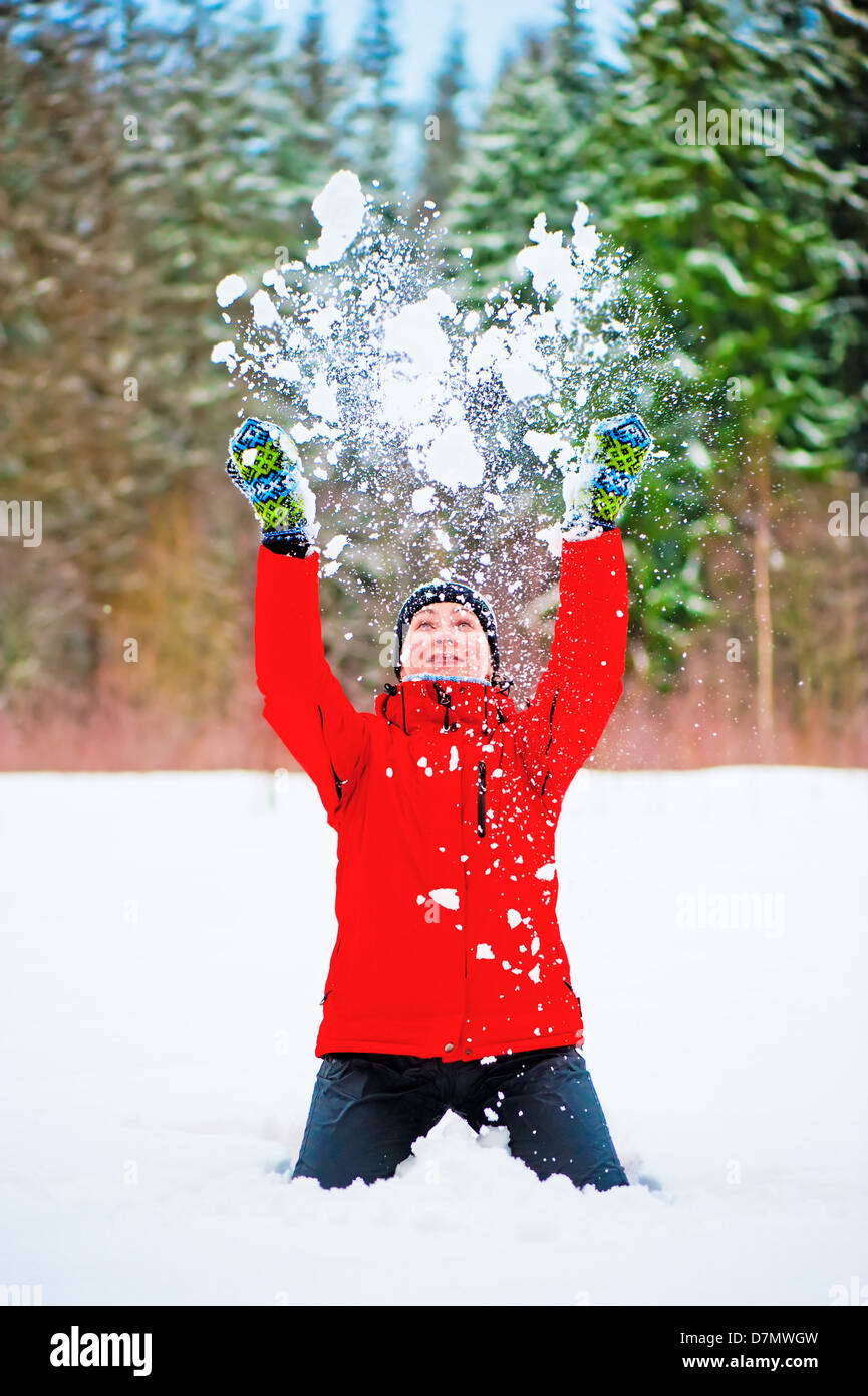 Female throwing a pile of snow up into the air. Female is in focus ...