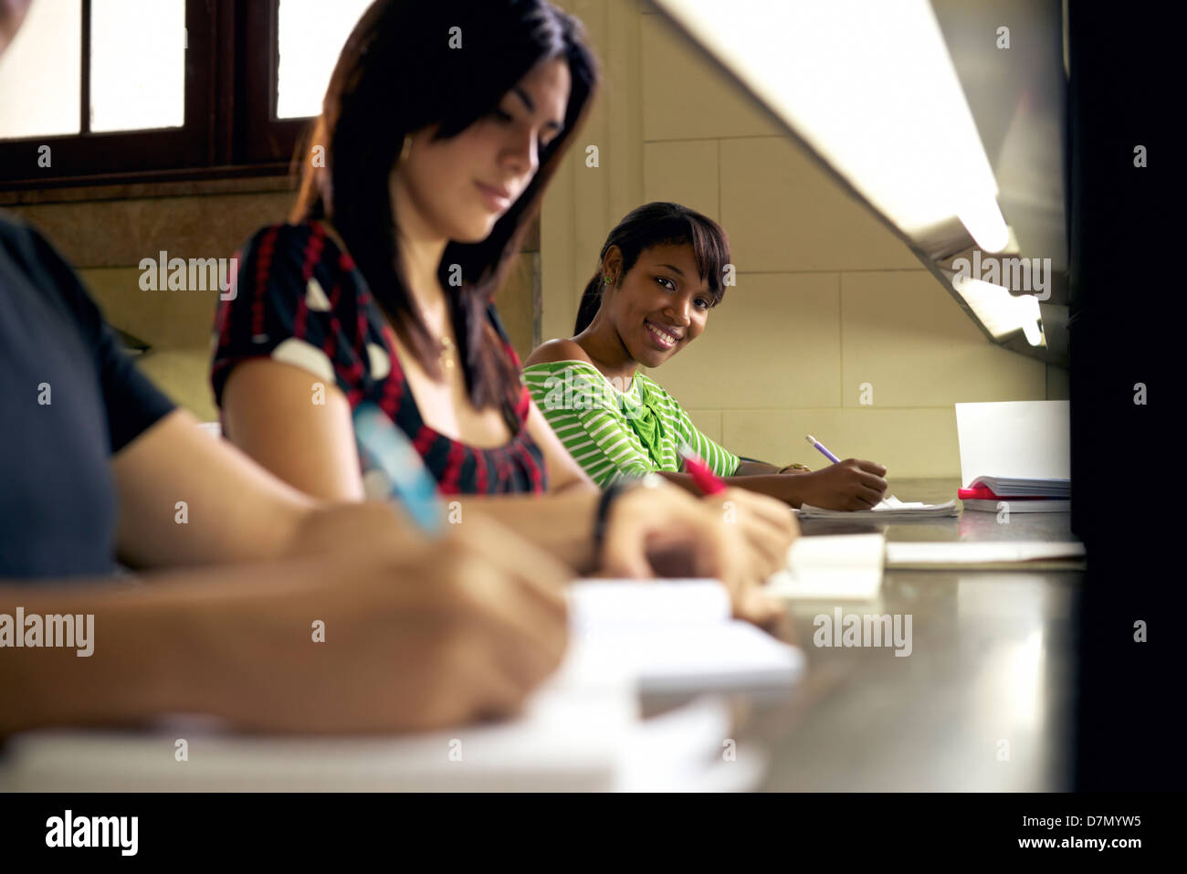 Portrait of happy female student writing and preparing test, pretty ...