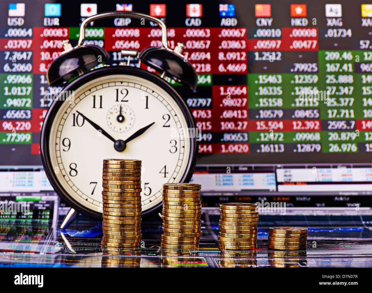 A downtrend stacks of golden coins with an alarm clock. Financial chart ...