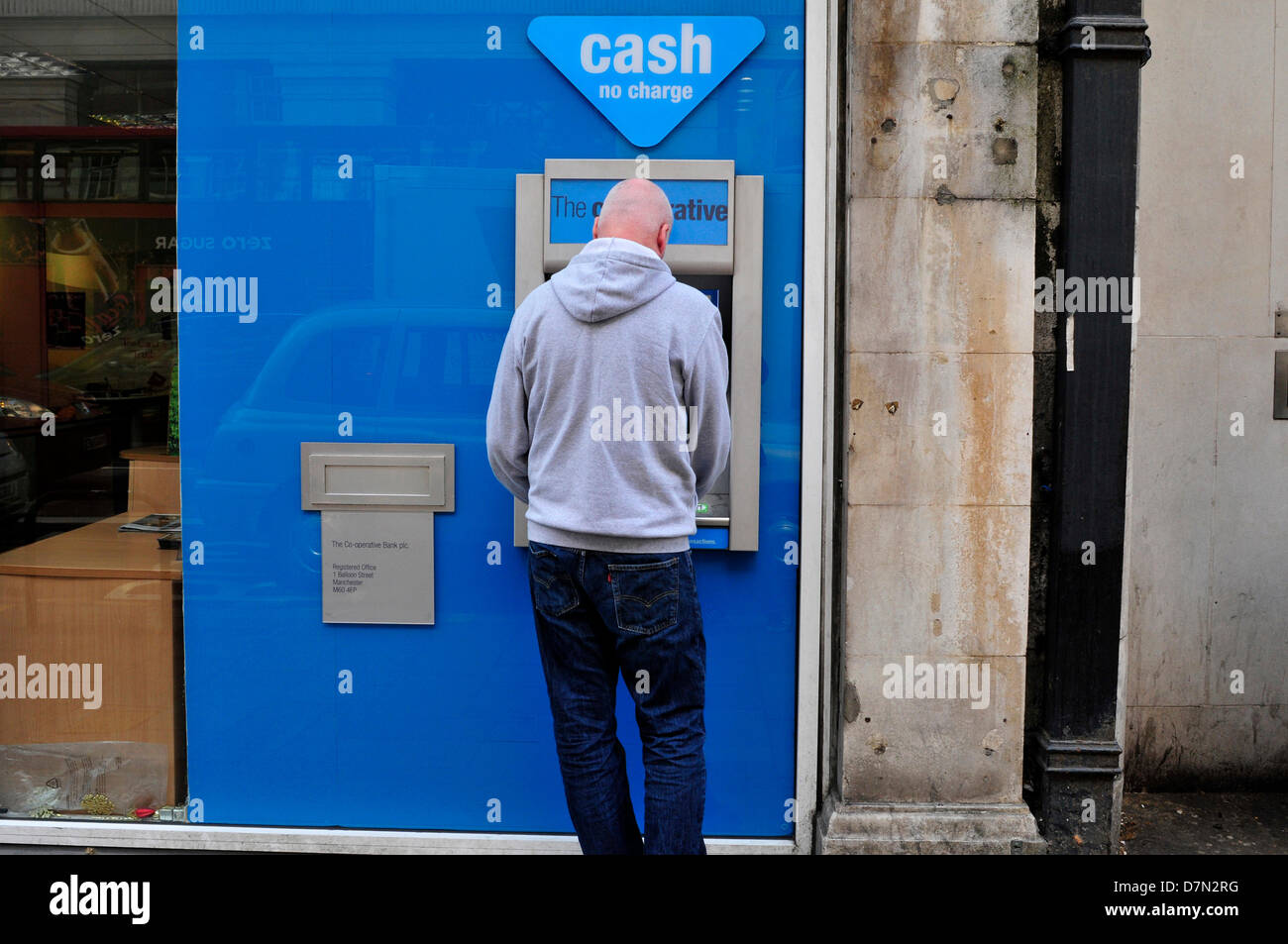 A man withdraws money from a cash machine at the Co-operative bank in ...