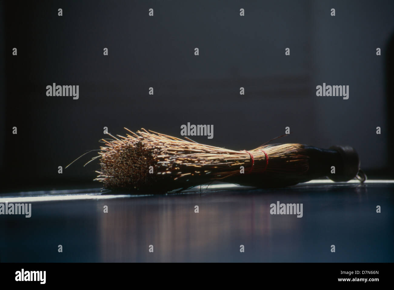 A straw dustbroom lays on the floor, ©mak Stock Photo - Alamy