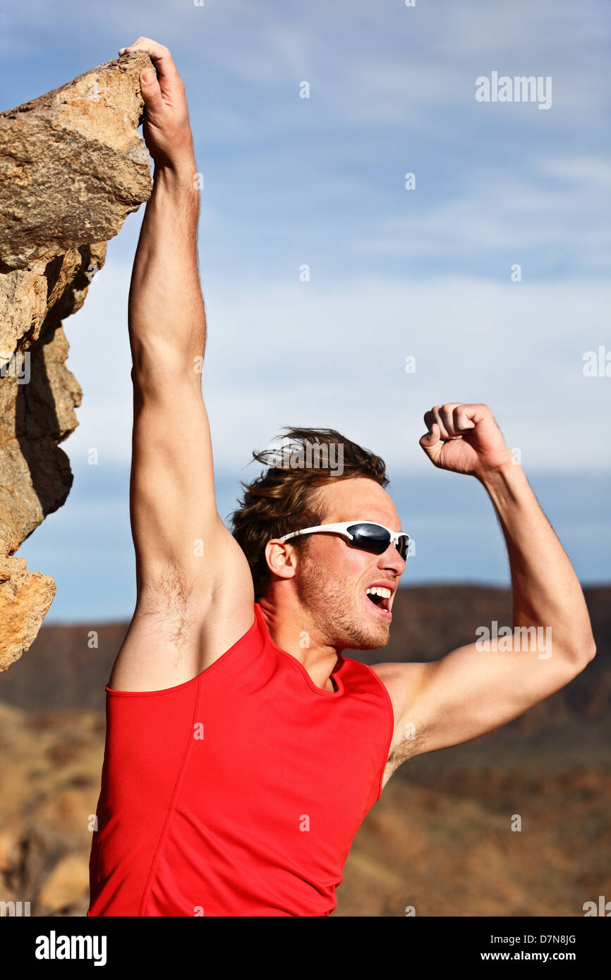 Success concept - man climbing, hanging on edge showing strength and ...
