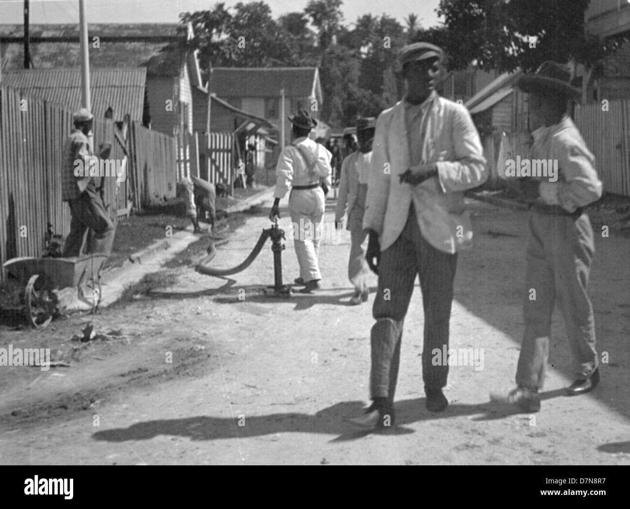 A photograph from 1898-1899, depicting a man pumping water on a street ...