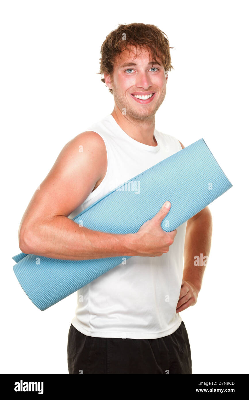 Fitness man holding yoga training mat. Young muscular sporty man ...