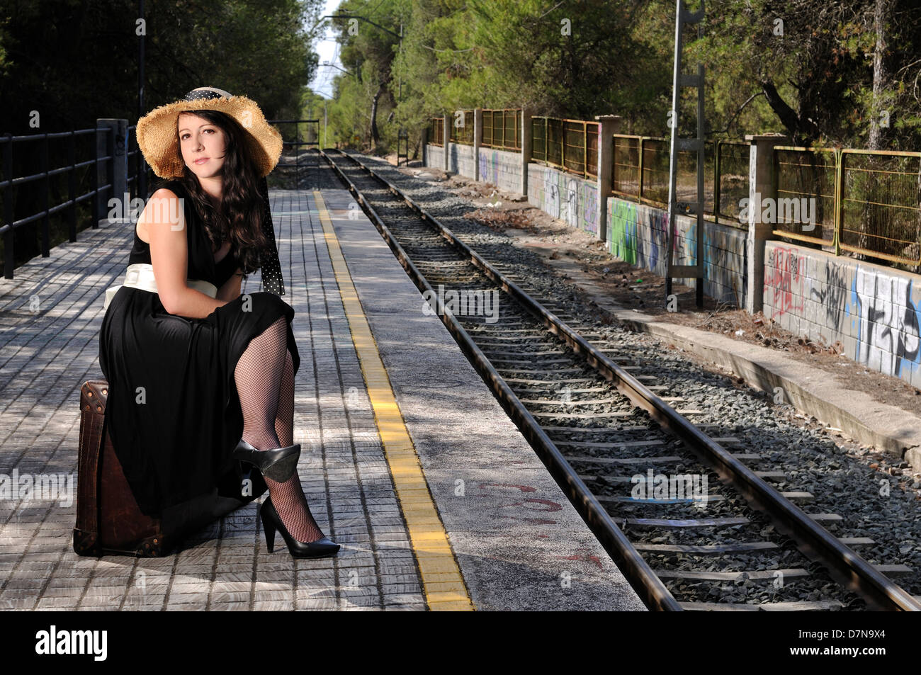 Woman waiting for a train at the station Stock Photo - Alamy
