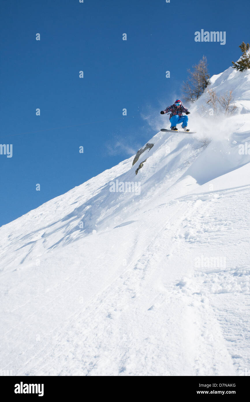 Snowboarder jumping a cliff Stock Photo - Alamy